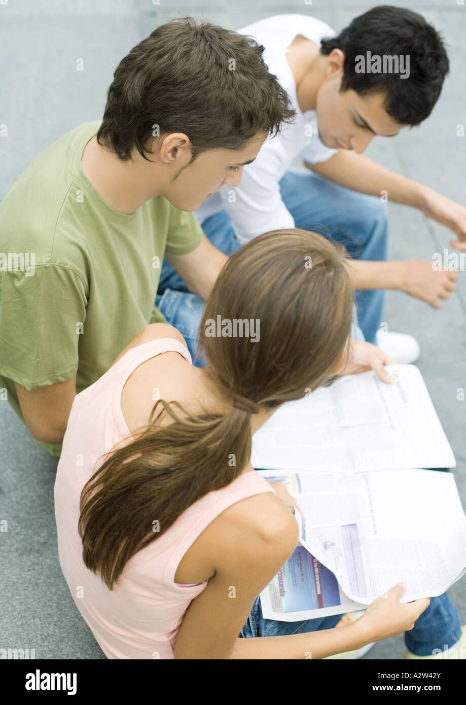 Teen friends, girl holding newspaper Stock Photo - Alamy