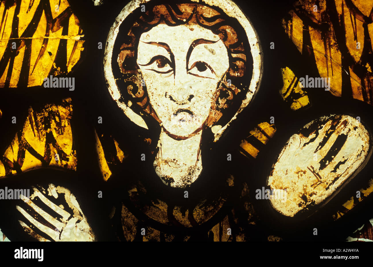 Detail of a medieval stained glass church window with a quirky angel ...