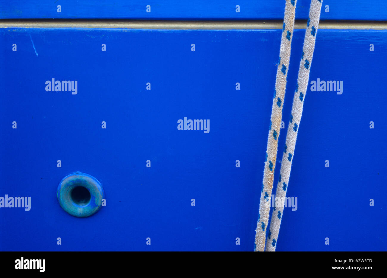 Detail of side of hull of boat or ship painted deep blue with two ...