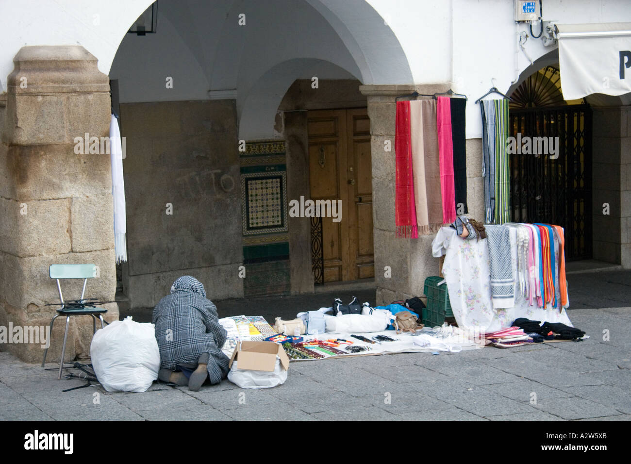 A lady kneels on ground as she sets up her market stall Stock Photo - Alamy