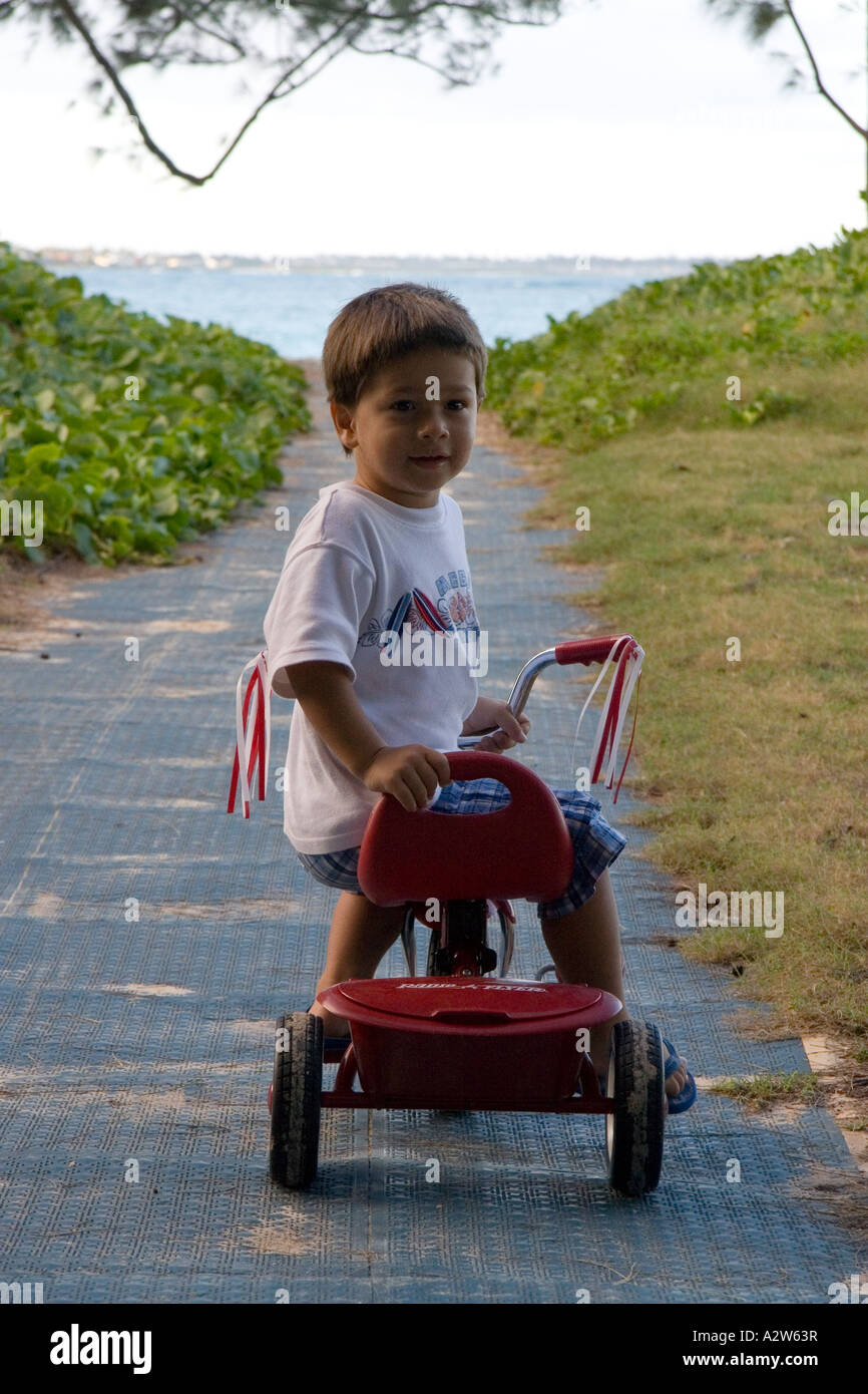 Toddler sitting on a red tricycle Stock Photo - Alamy