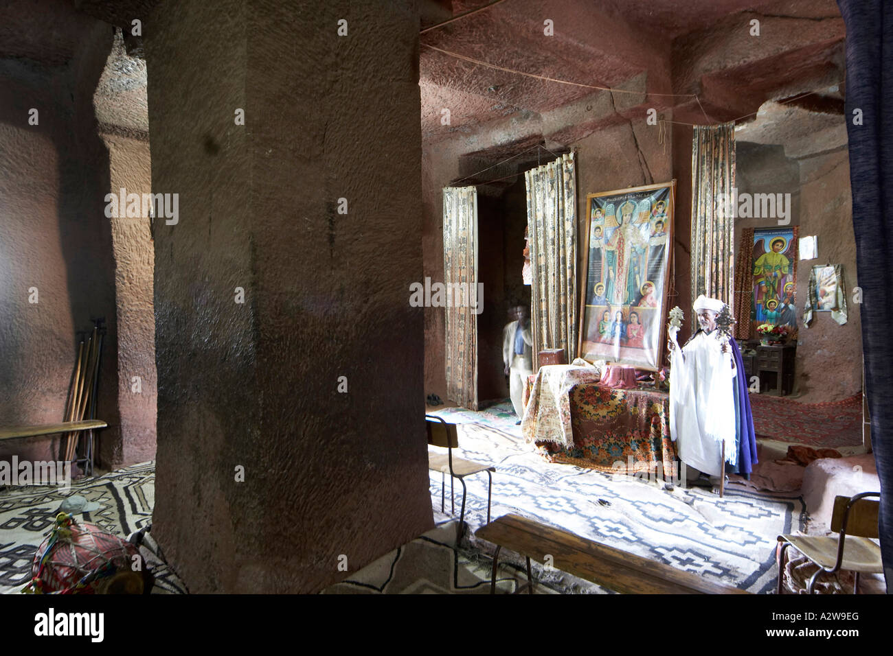 Priest with cross curtain drapes and paintings in Bet Gabriel Rafael ...