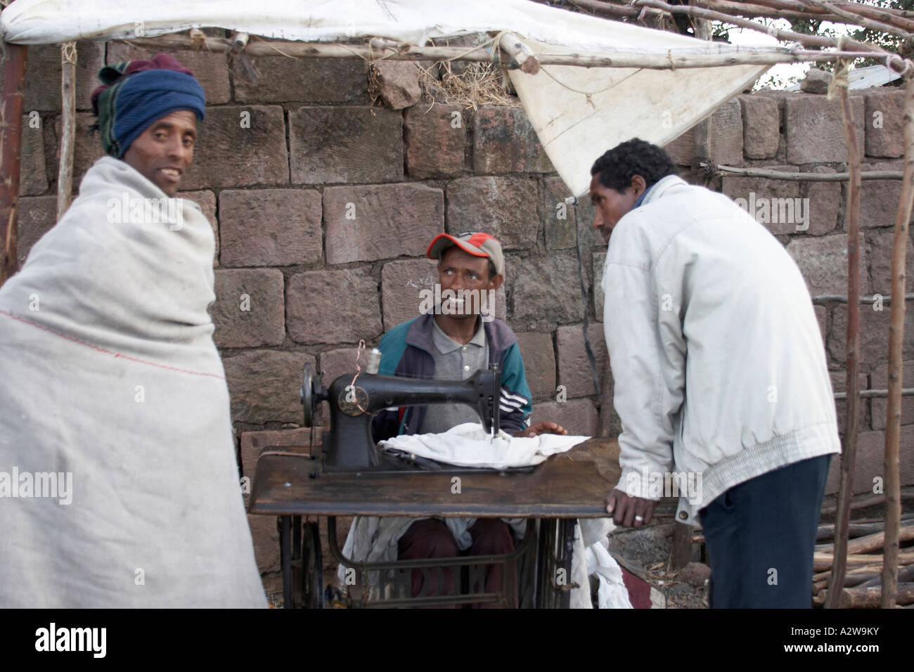 Three men one man sewing in Lalibela Ethiopia Africa Stock Photo - Alamy