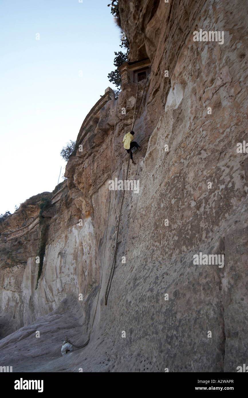 Monk or priest climbing ascending or descending rope to Debre Damo ...