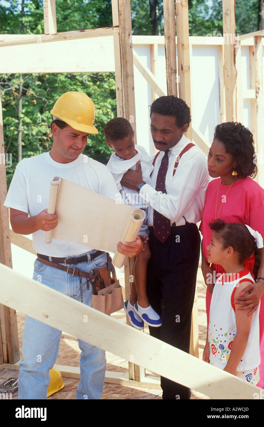 Family checks house plans with builder during house consruction Stock ...