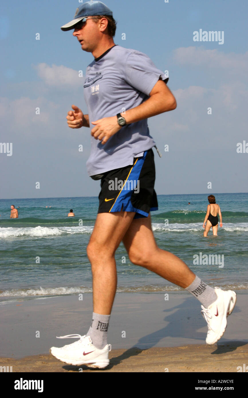 a young man jogging on the beach Stock Photo - Alamy