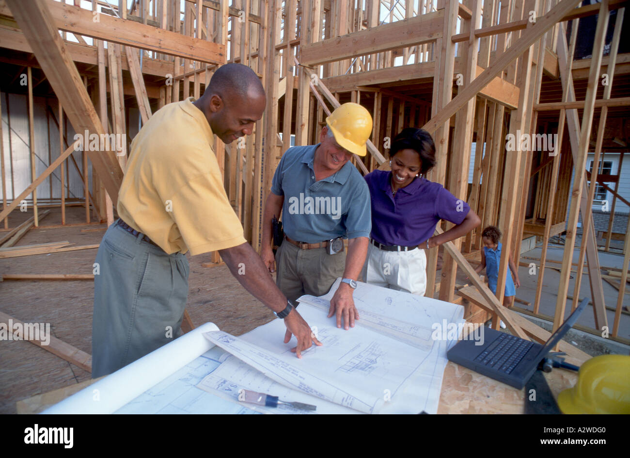 Family discusses house plans with architect during home construction ...