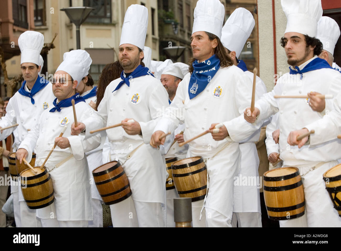 Basque men in white chefs outfits drumming on barrels, La Tamborrada ...