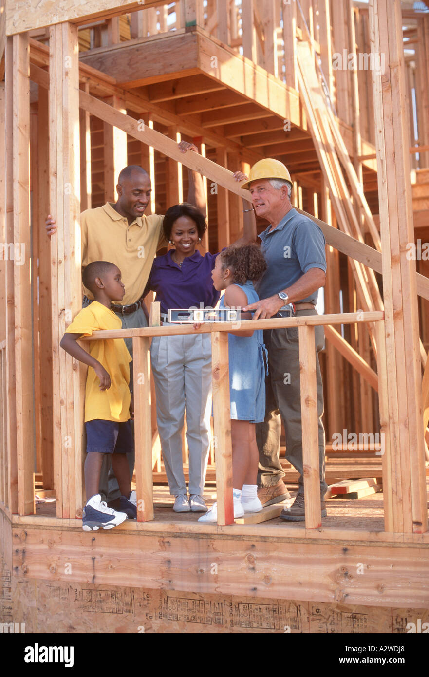 Family with builder during house construction Stock Photo - Alamy