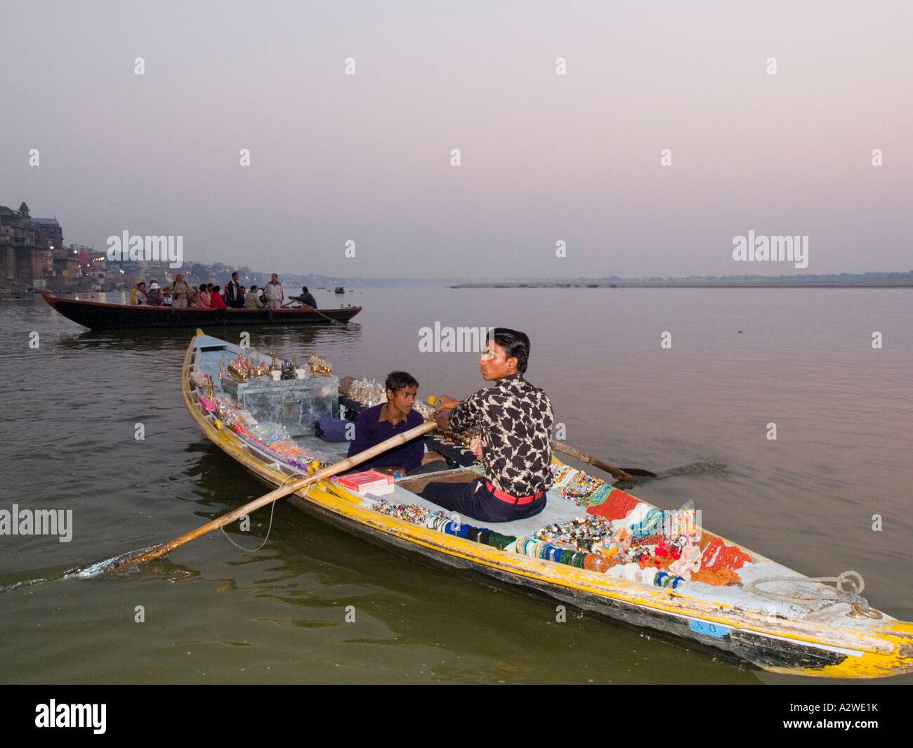 Indian men in rowing boat with souvenirs to sell following tourists on ...
