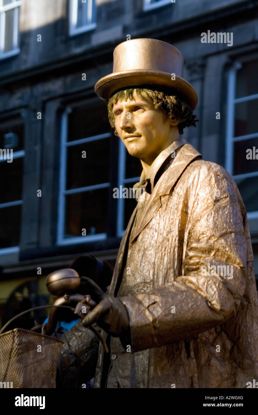Mime artist dressed as a golden statue with a bicycle at the Edinburgh ...