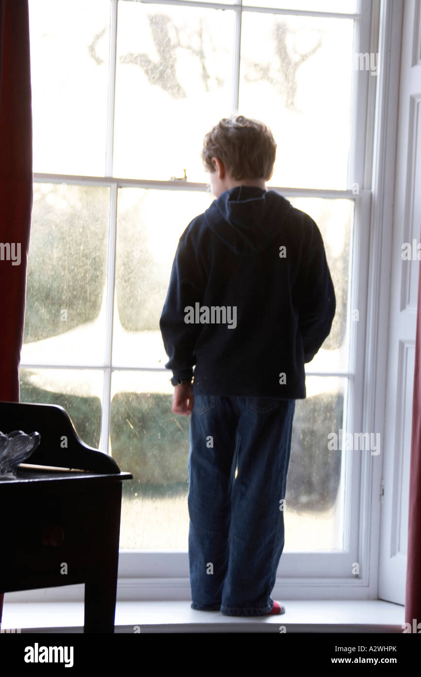 Young boy child looking out of Georgian sash windows at Ballynascreen ...