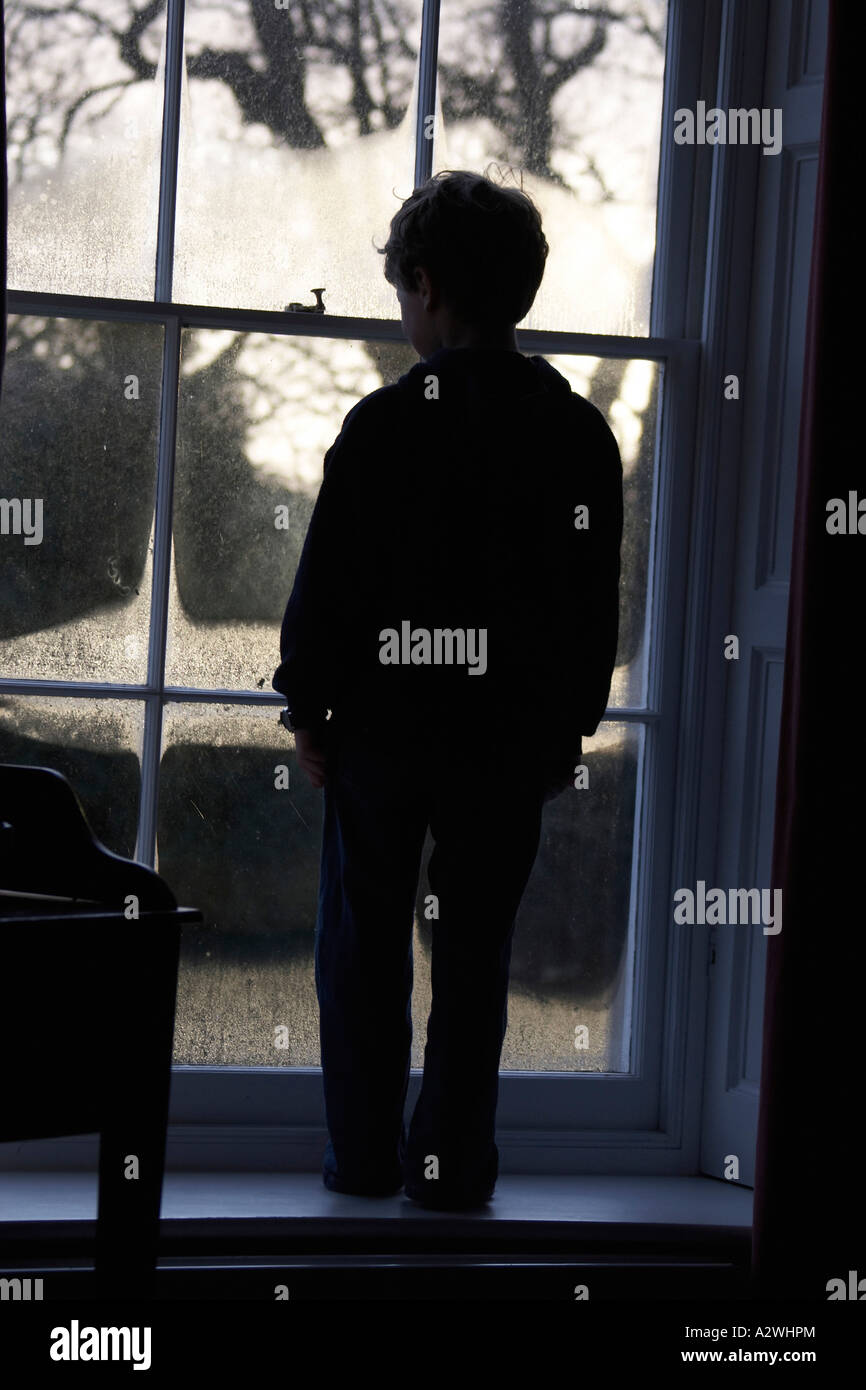 Young boy child looking out of Georgian sash windows at Ballynascreen ...