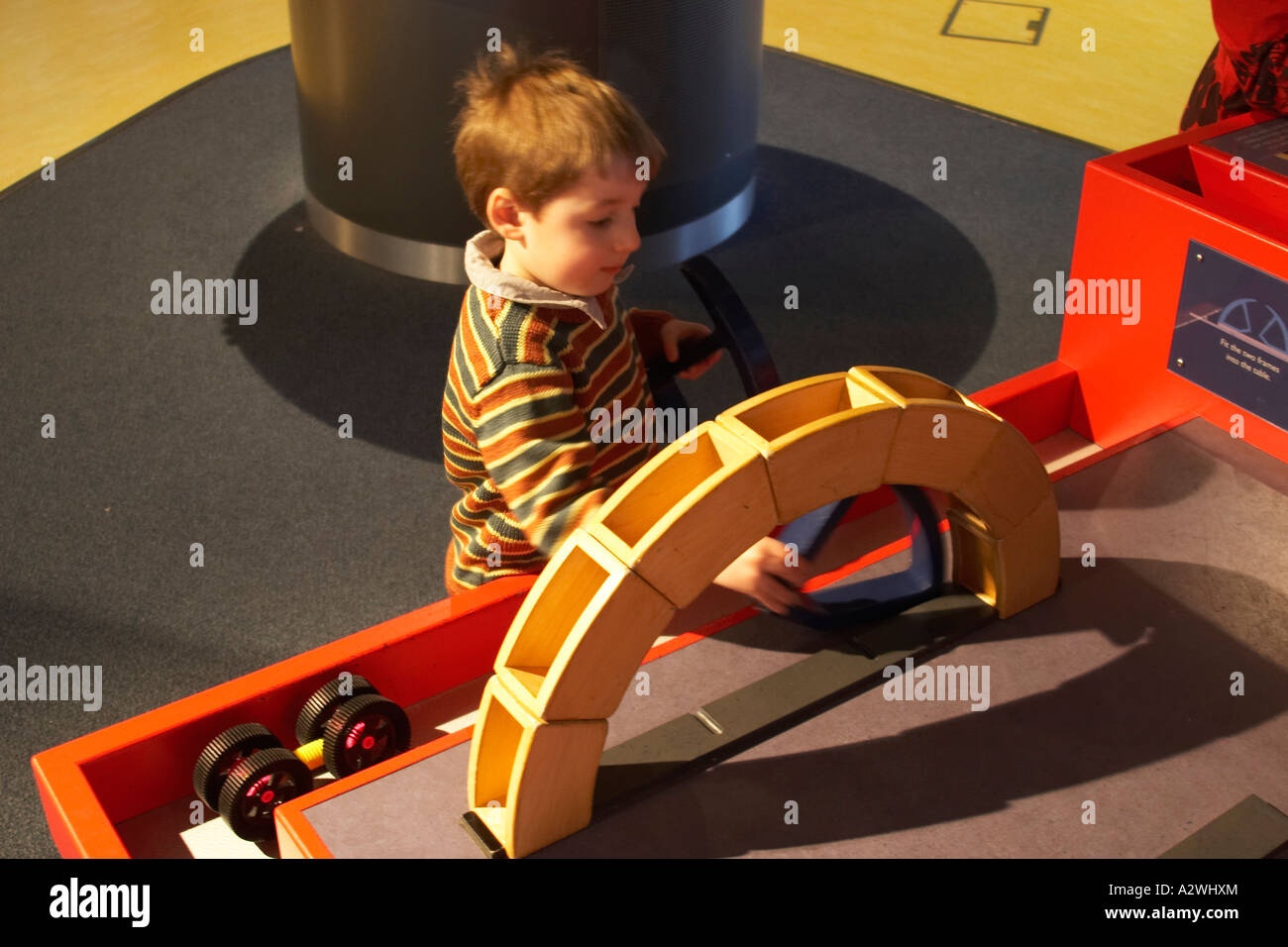 Young boy child playing building a wooden arch in Odyssey W5 ...