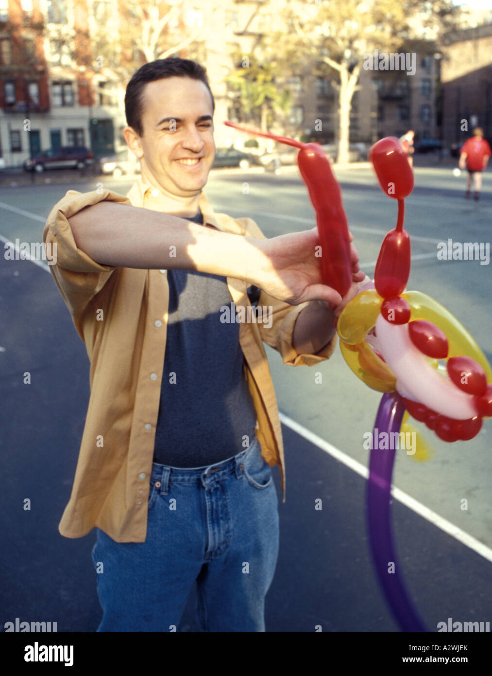 Young man inflating balloons, smiling Stock Photo - Alamy