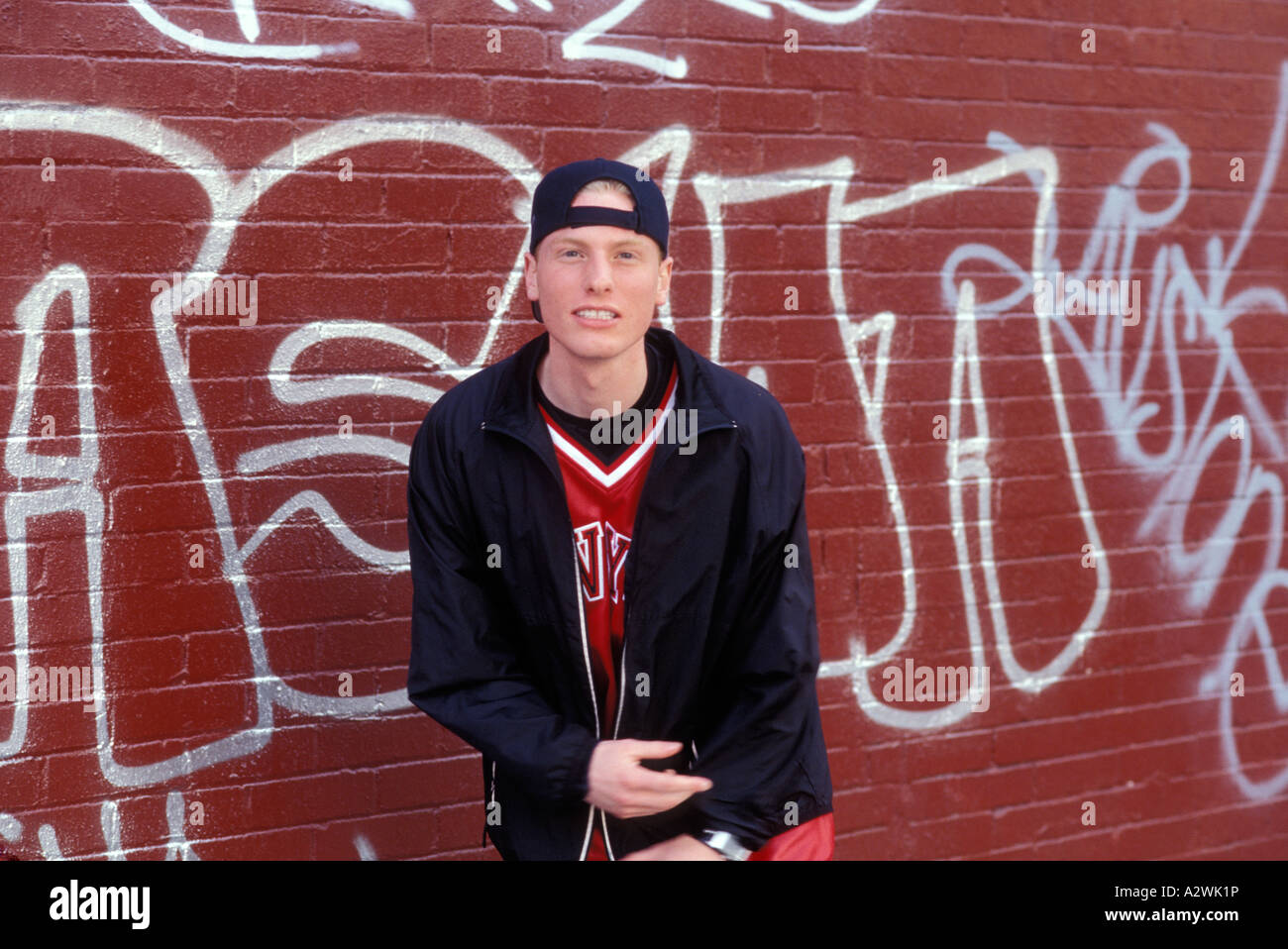 Young man standing by wall, portrait Stock Photo - Alamy