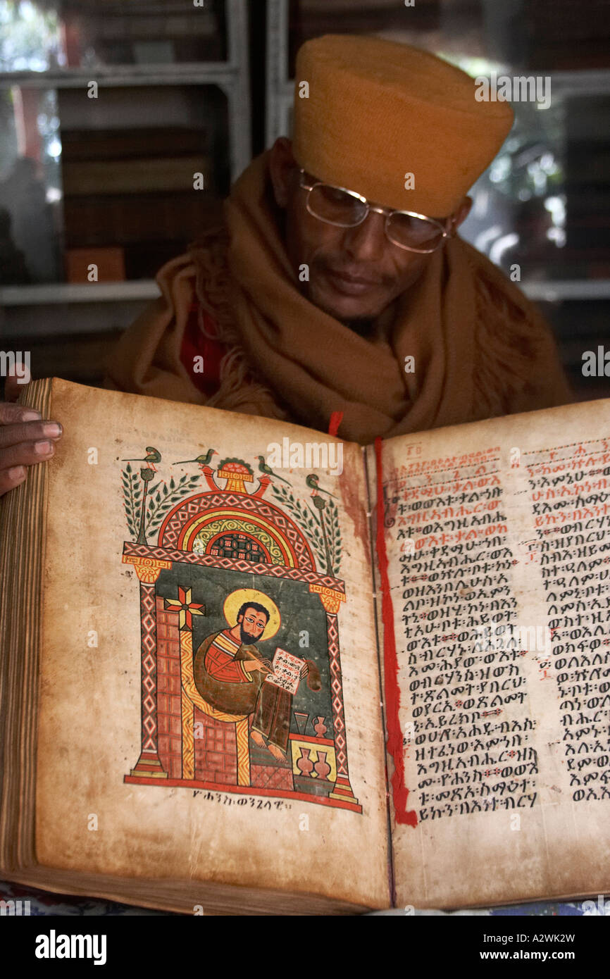 Monk showing old 1555 illuminated manuscript parchment book of gospels ...