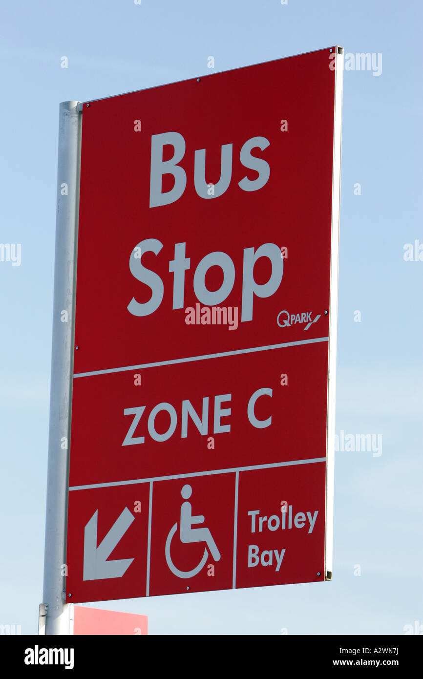 red bus stop sign at qpark car park against blue sky at Belfast ...