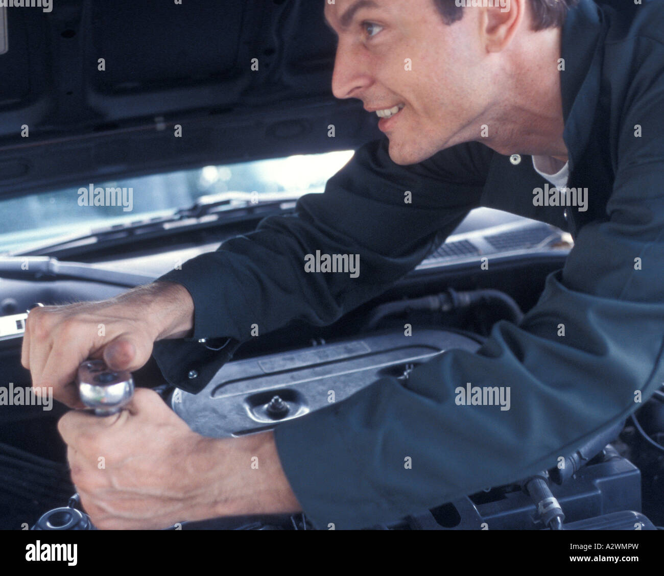 Young man working on engine Stock Photo - Alamy
