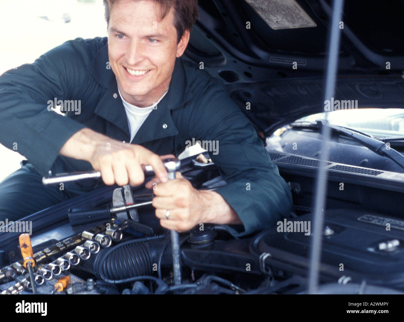 Young man working on engine Stock Photo - Alamy