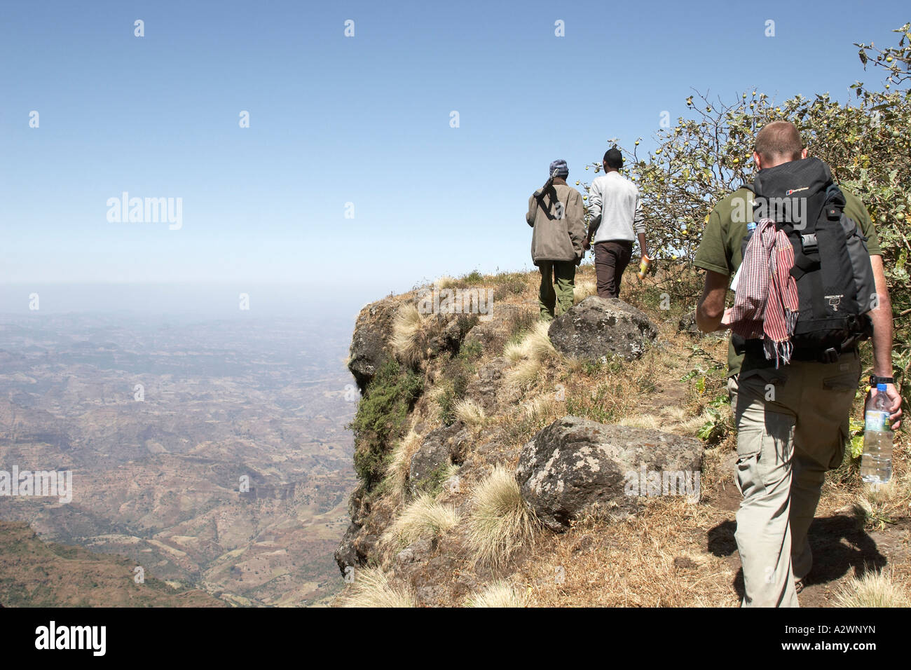 People walking along escarpment cliffs in Simien Mountains National ...