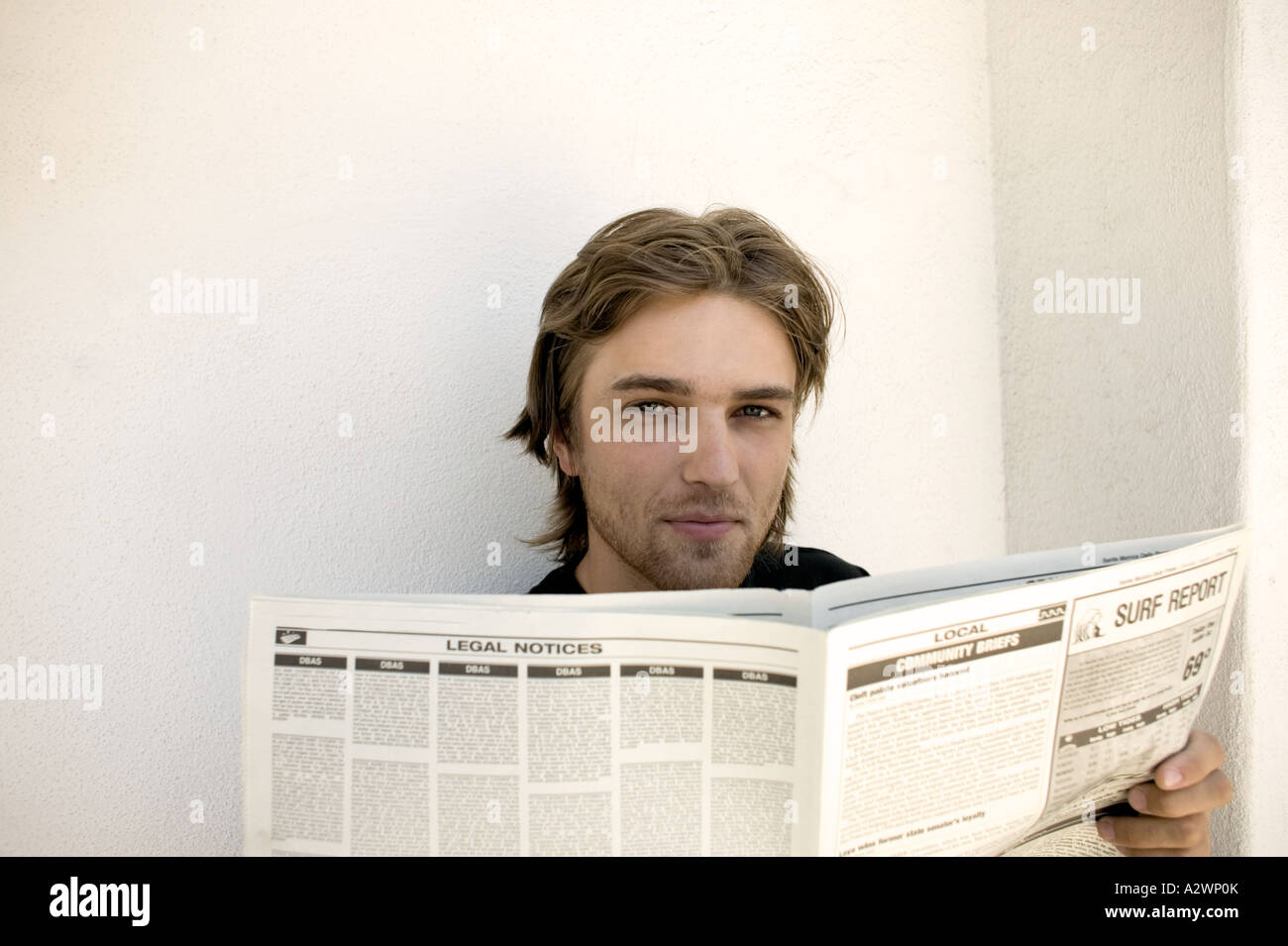 Young man holding newspaper, portrait Stock Photo - Alamy