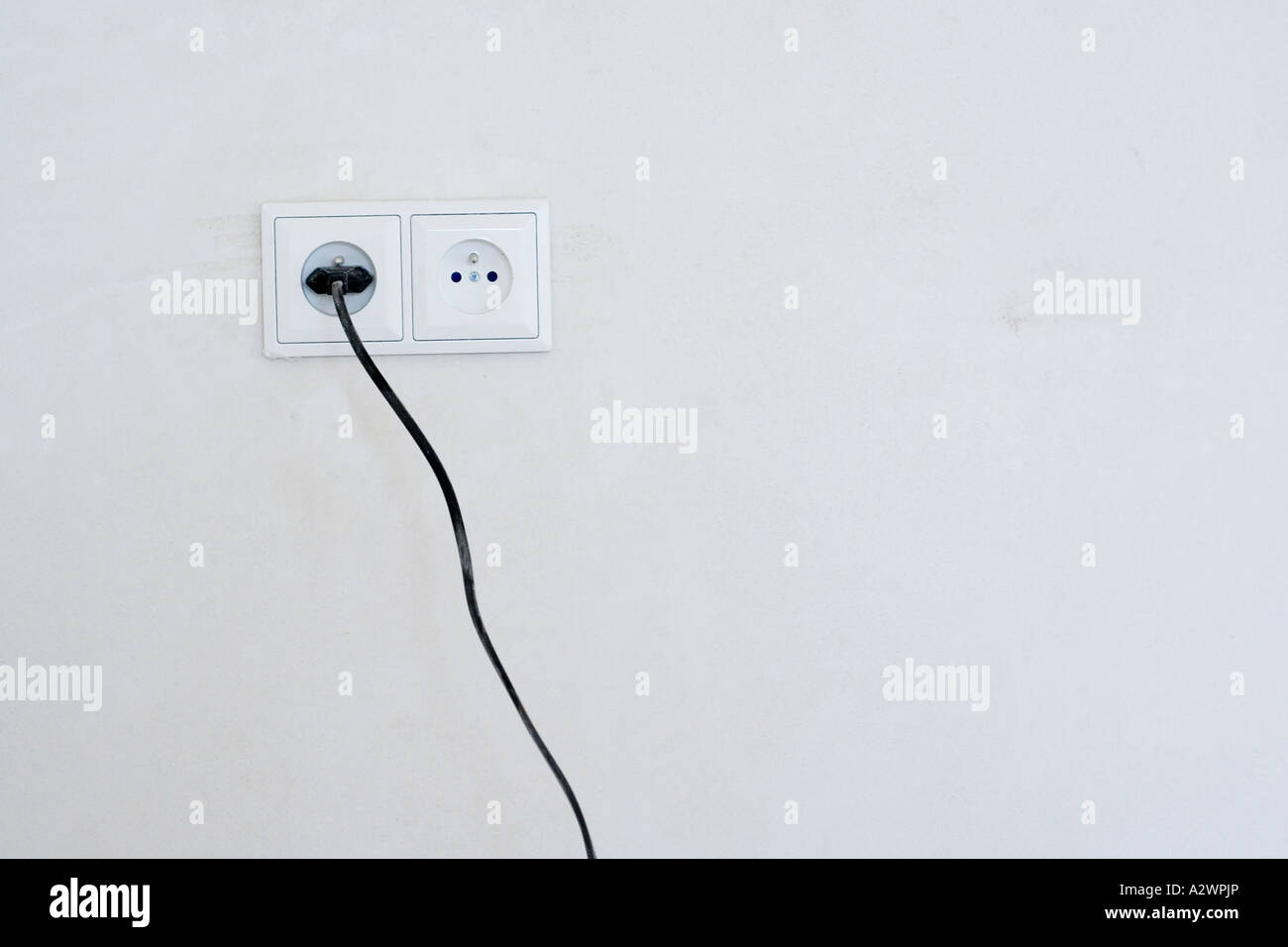 Extension cord pulling out of electric outlet Stock Photo - Alamy