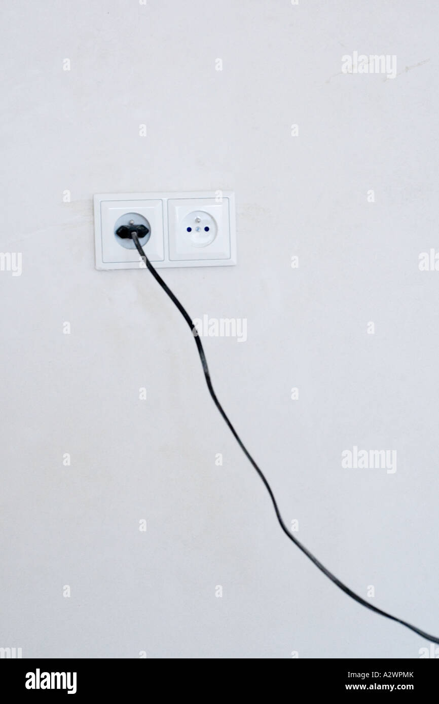 Extension cord pulling out of electric outlet Stock Photo - Alamy