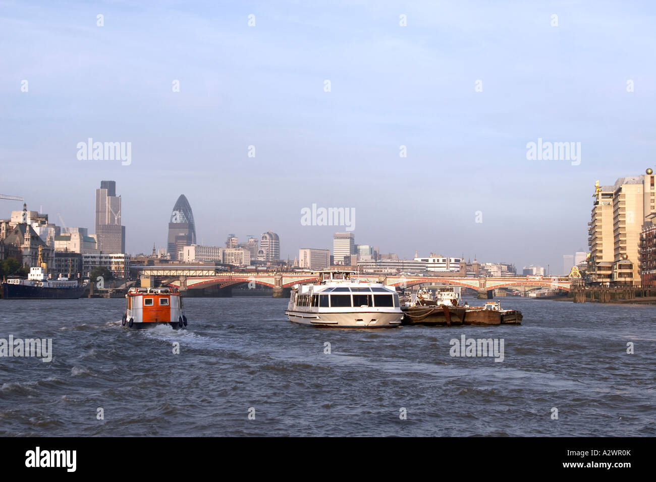 Tourist ships and cruise boats on River Thames with Waterloo Bridge and ...