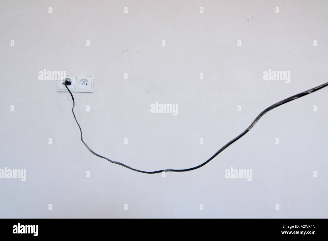 Extension cord pulling out of electric outlet Stock Photo - Alamy