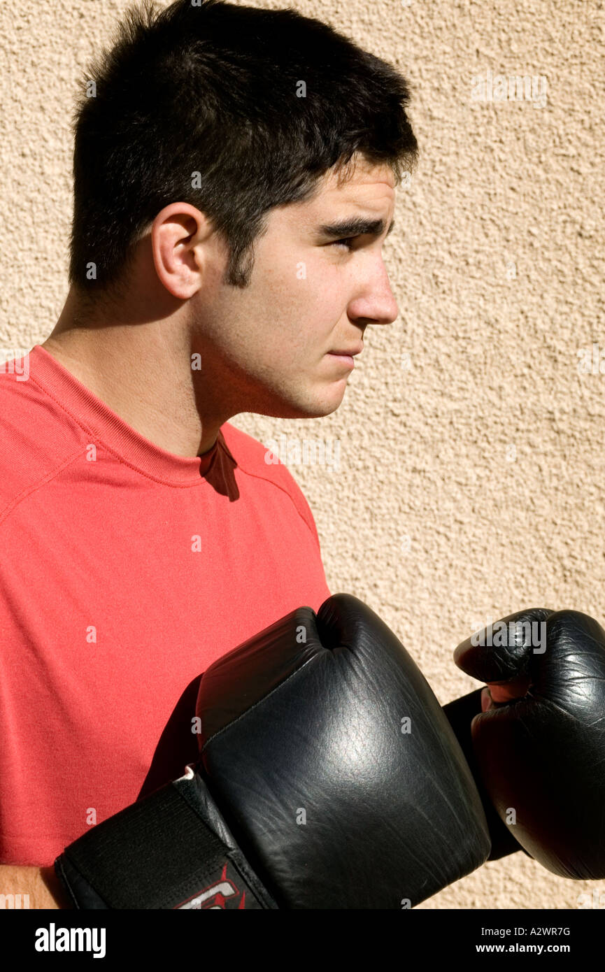 Young man wearing boxing gloves, side view Stock Photo - Alamy