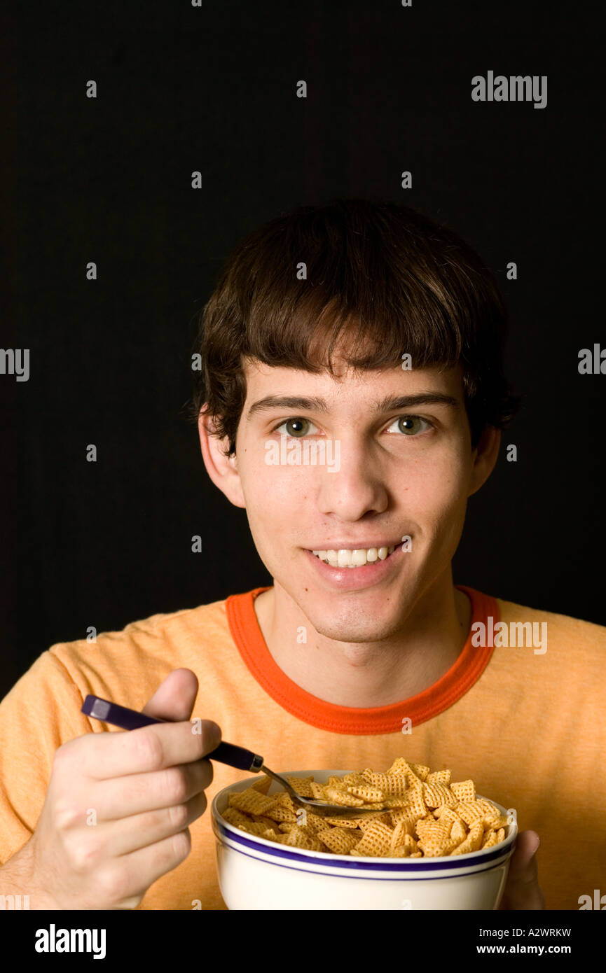 Young man holding bowl of snack, portrait Stock Photo - Alamy