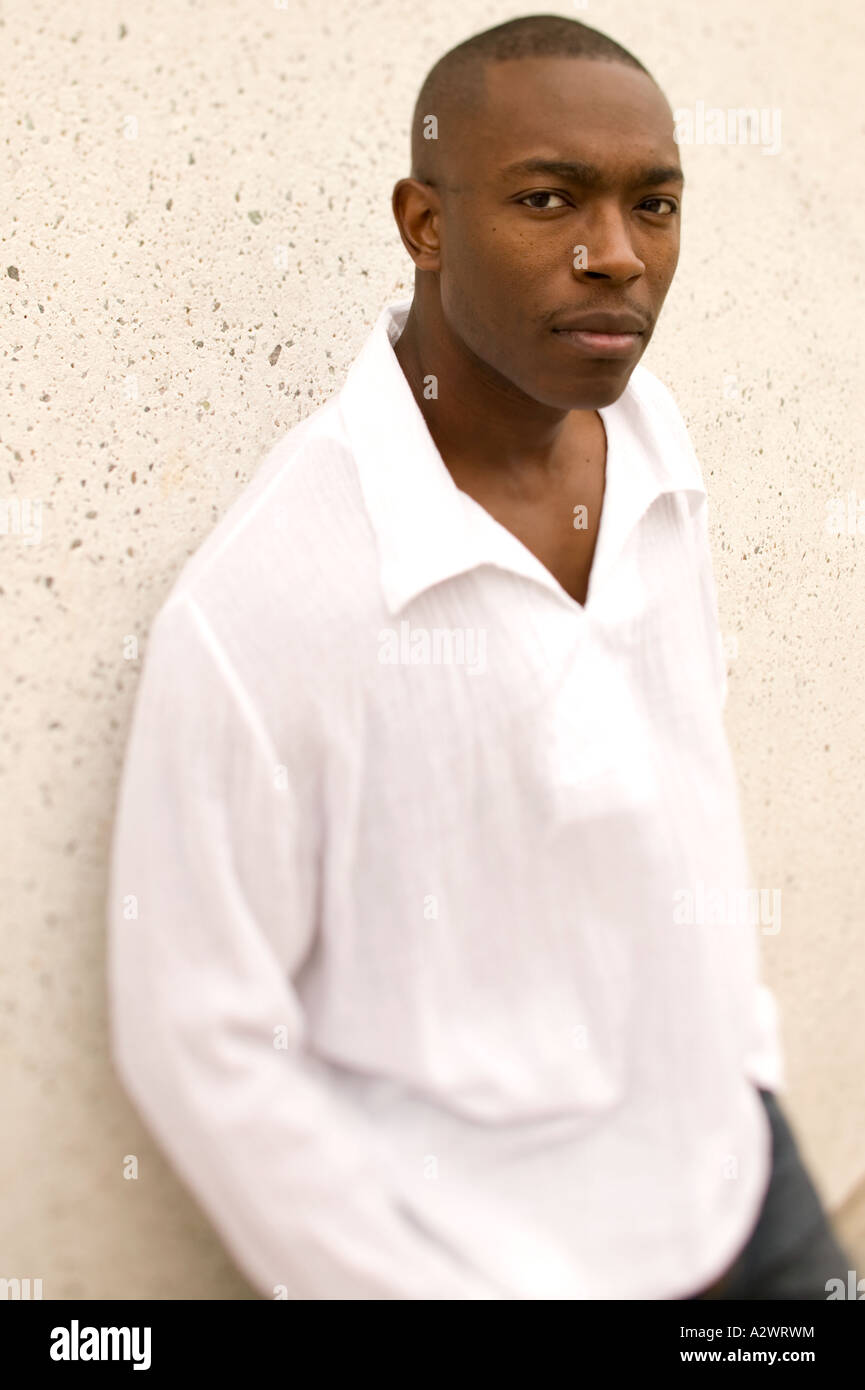 Young man standing by wall, portrait Stock Photo - Alamy