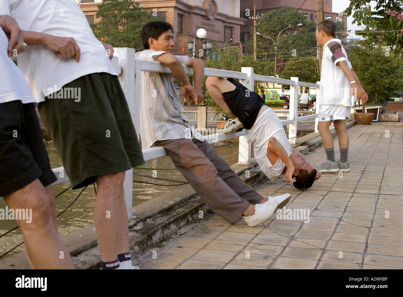 Hanging upside-down during early morning exercise at Mei Linh Square ...