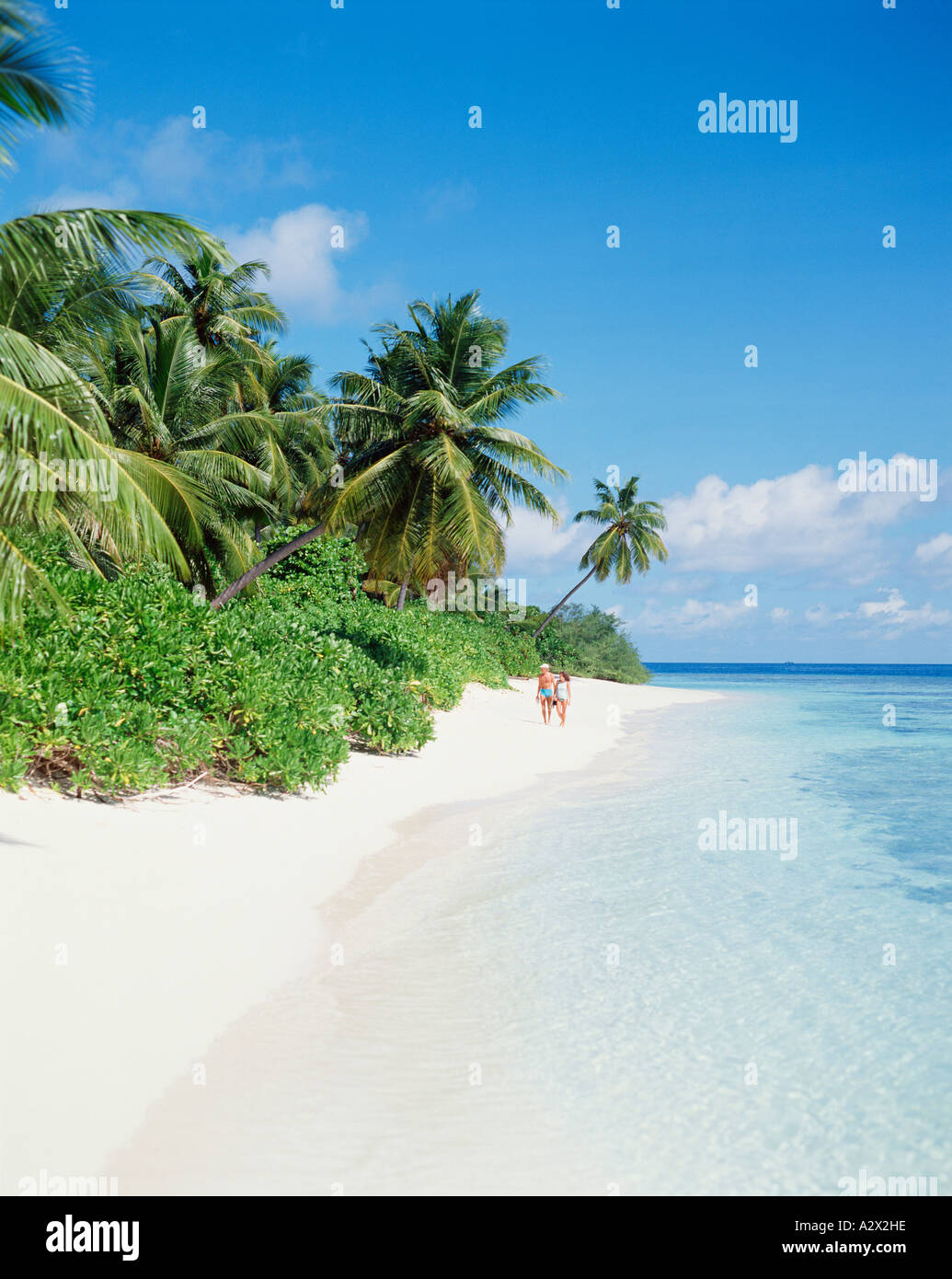 Maldives. Tropical beach with distant couple Stock Photo - Alamy
