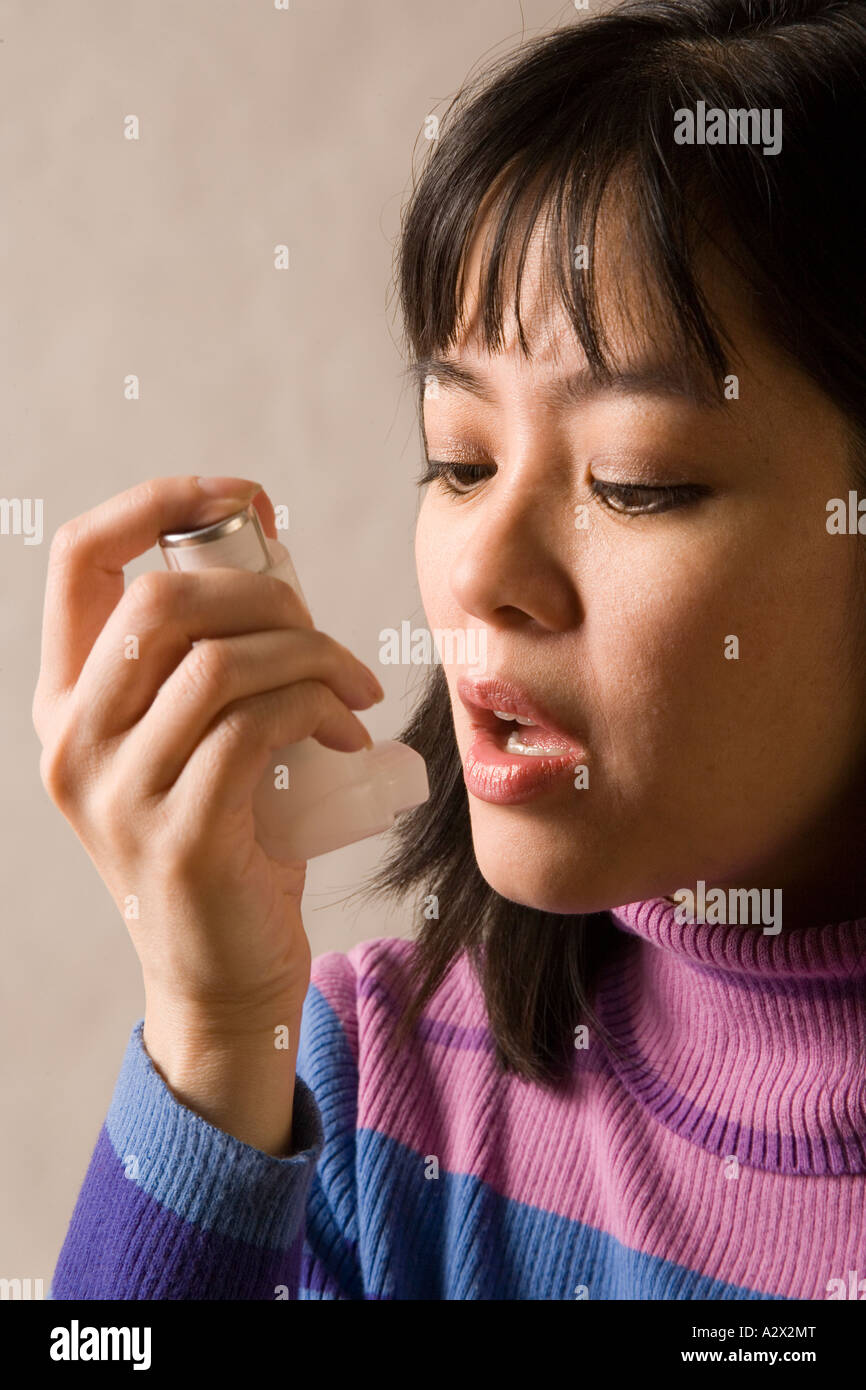 Woman using bronchial inhaler to relieve asthma symptoms Stock Photo ...