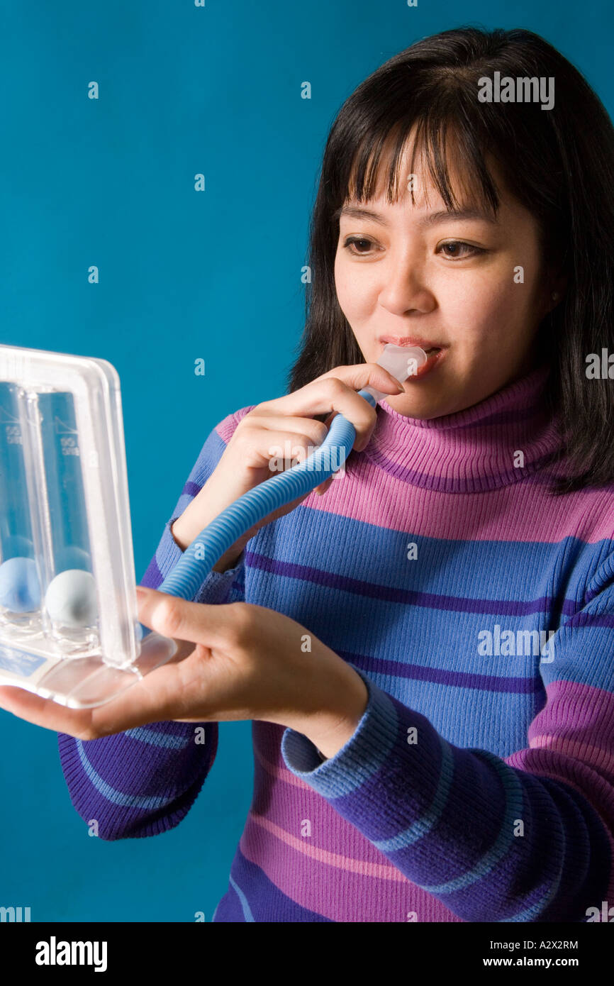 Young woman using a lung capacity pulmonary test Stock Photo - Alamy