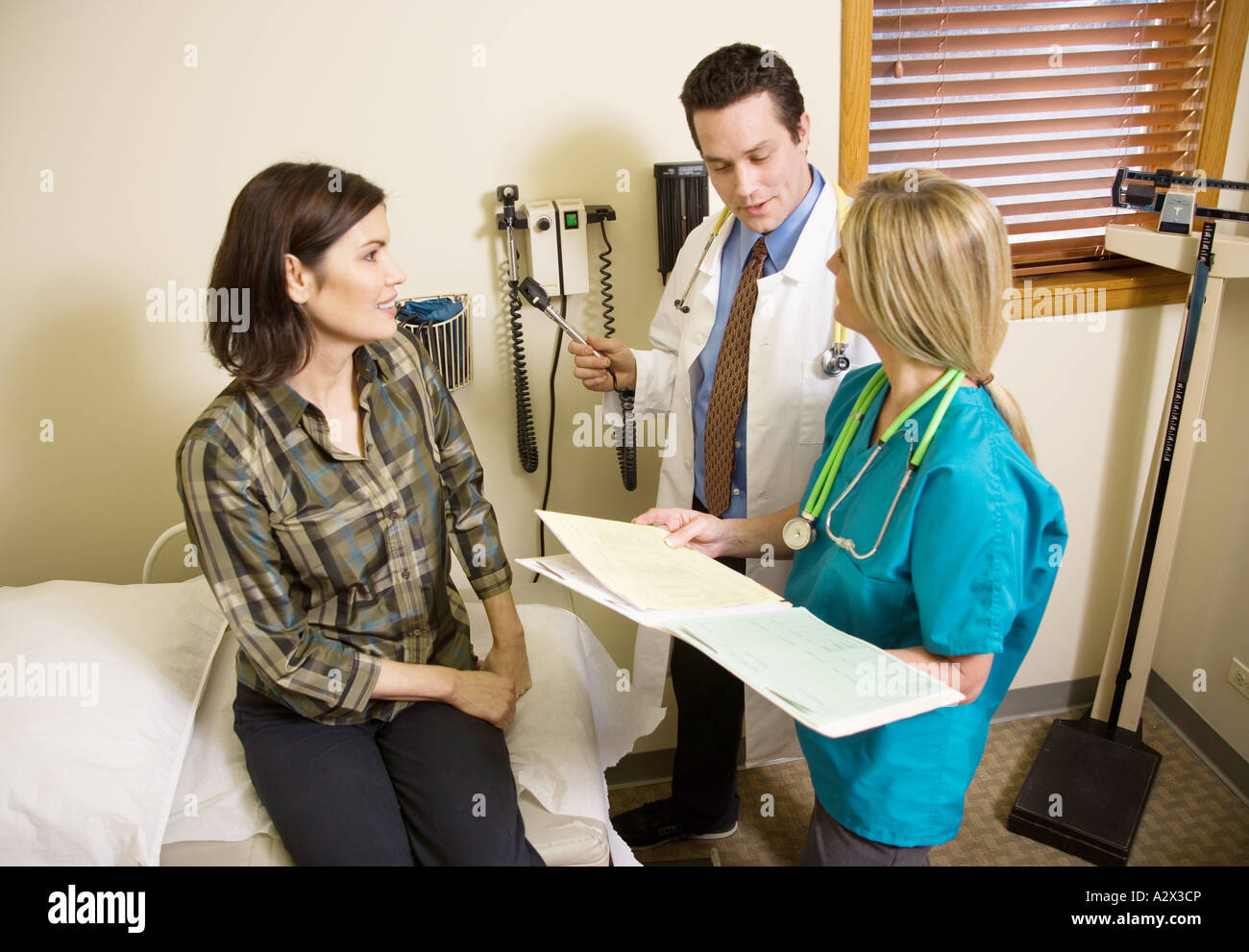 Doctor and nurse discuss the patients diagnosis or prognosis in the ...