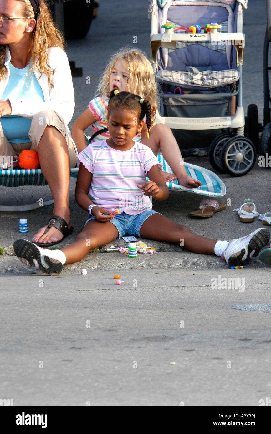 Children sitting on the sidewalk playing Stock Photo - Alamy