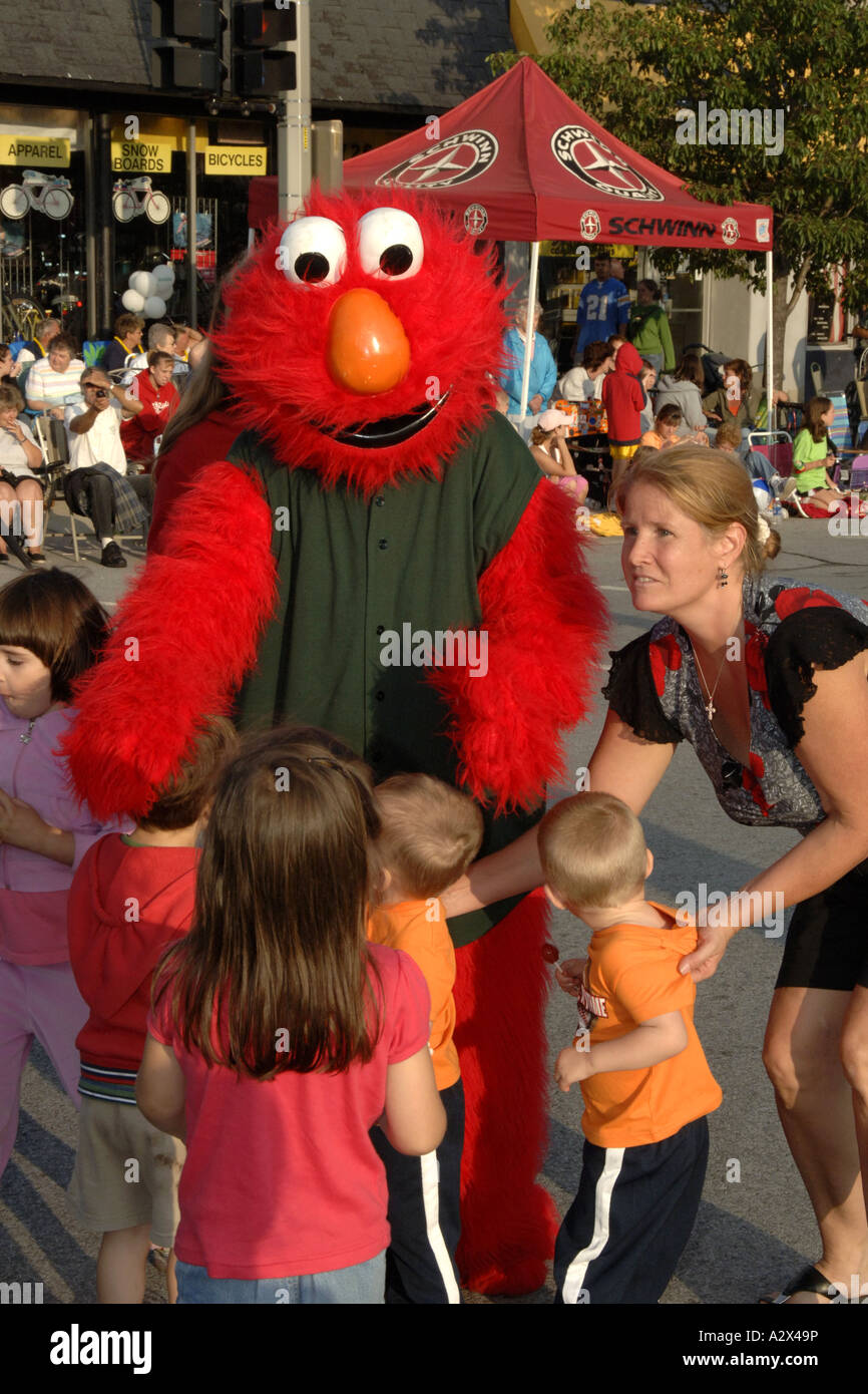 Children surrounding Elmo as he walks in a street parade Stock Photo ...