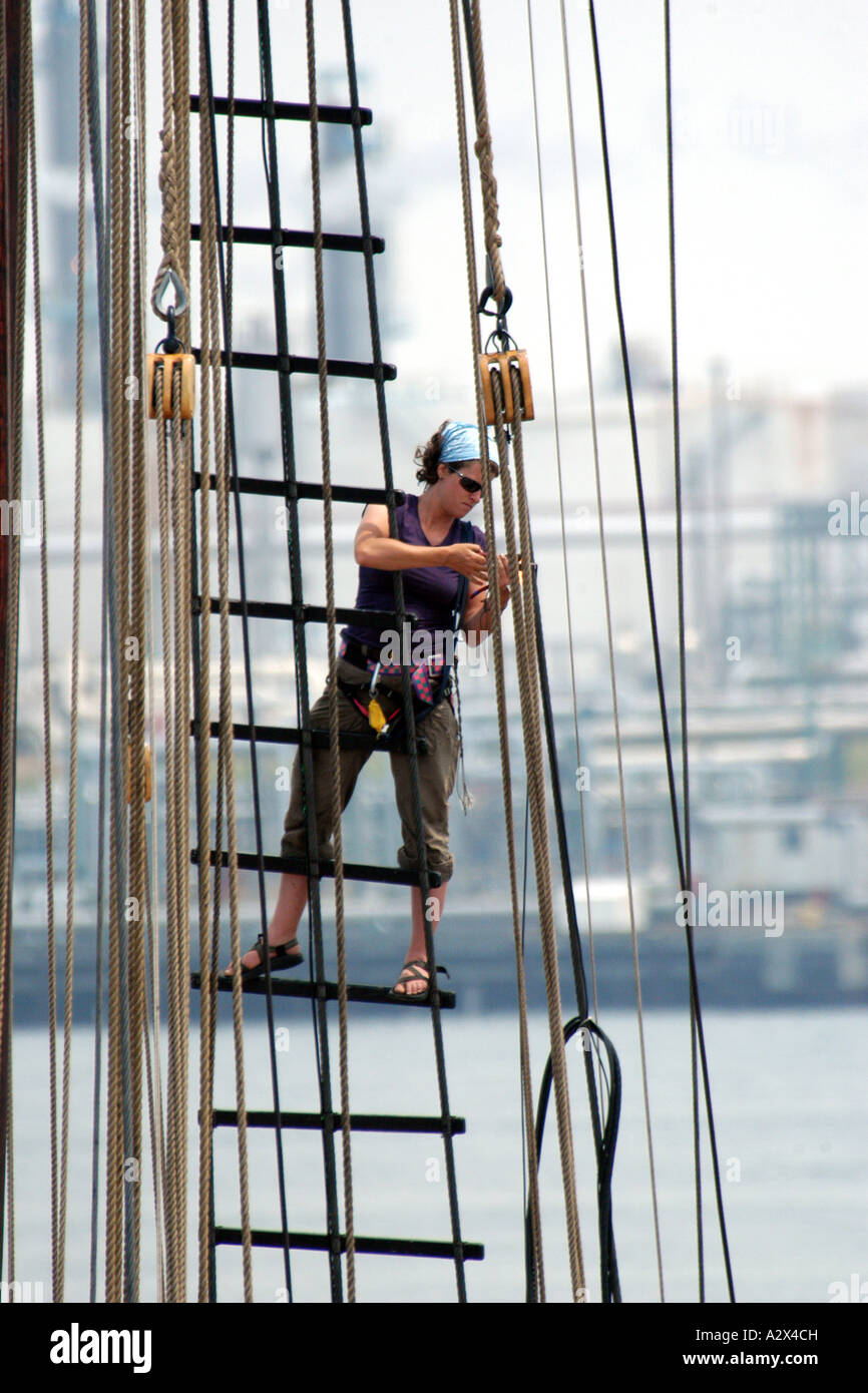 Female crew member onboard a tall masted ship working high up in the ...