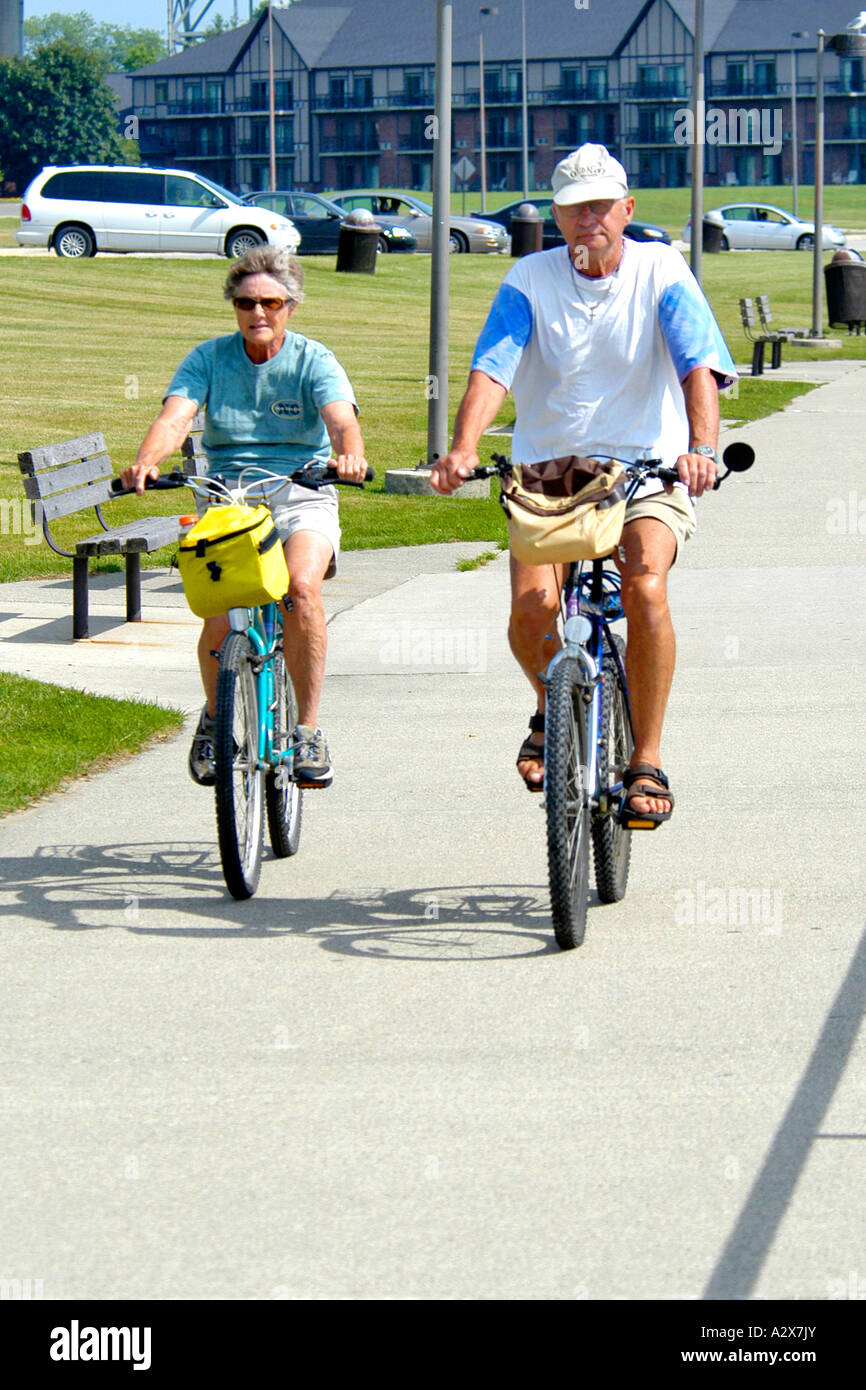 Adult male and female riding bicycles together Stock Photo - Alamy