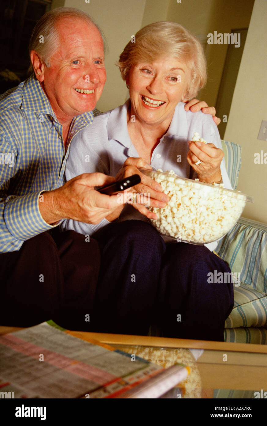 Old man and woman watching TV and snacking on popcorn Stock Photo - Alamy