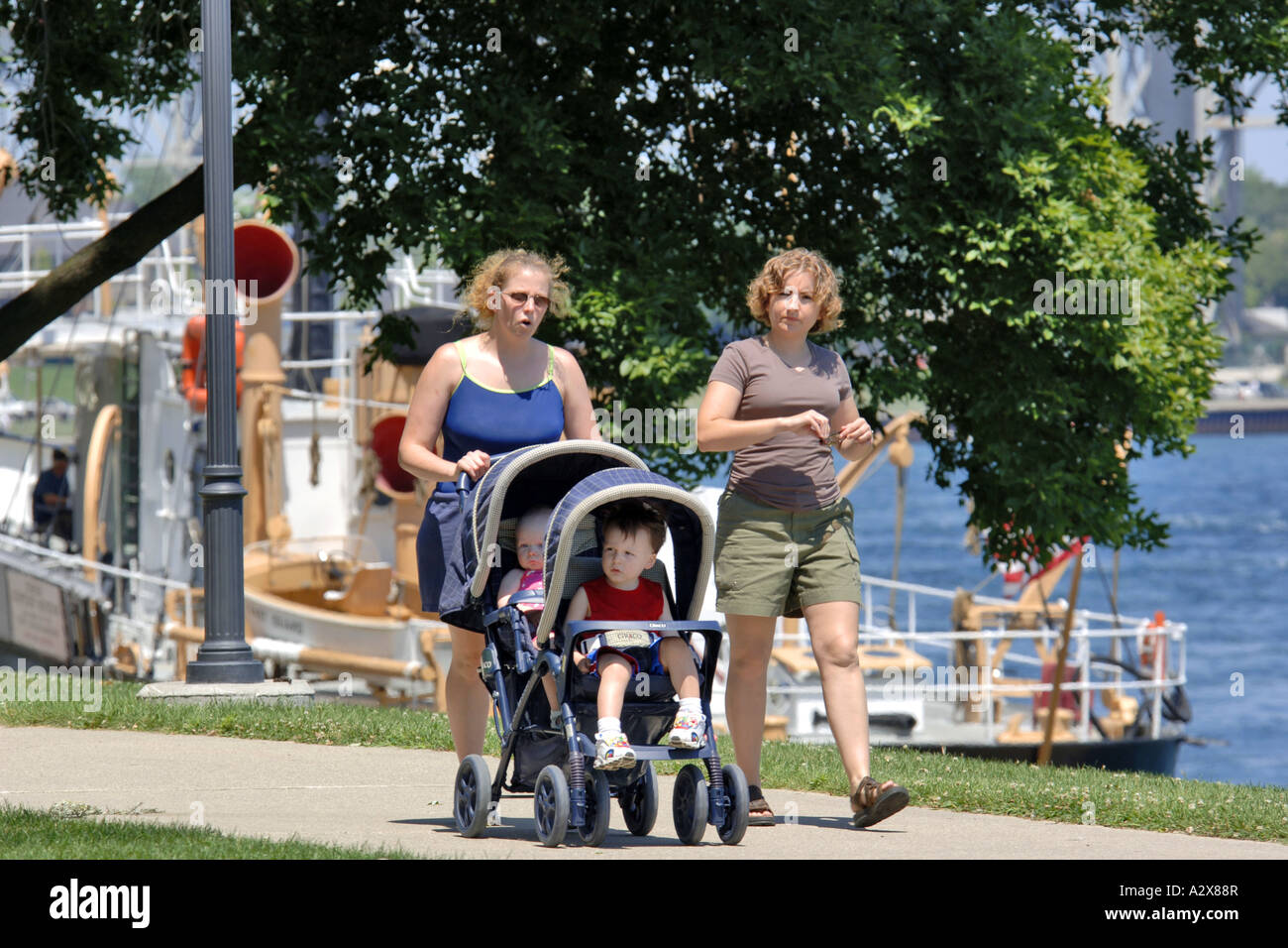 Mother pushing a double baby buggy Stock Photo - Alamy