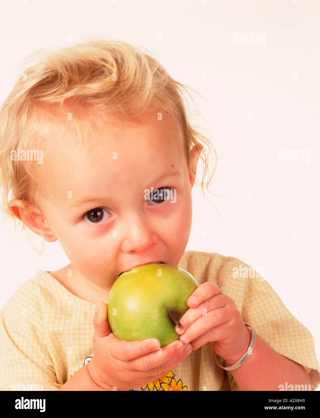 Indoor portrait of little girl child eating an apple Stock Photo - Alamy