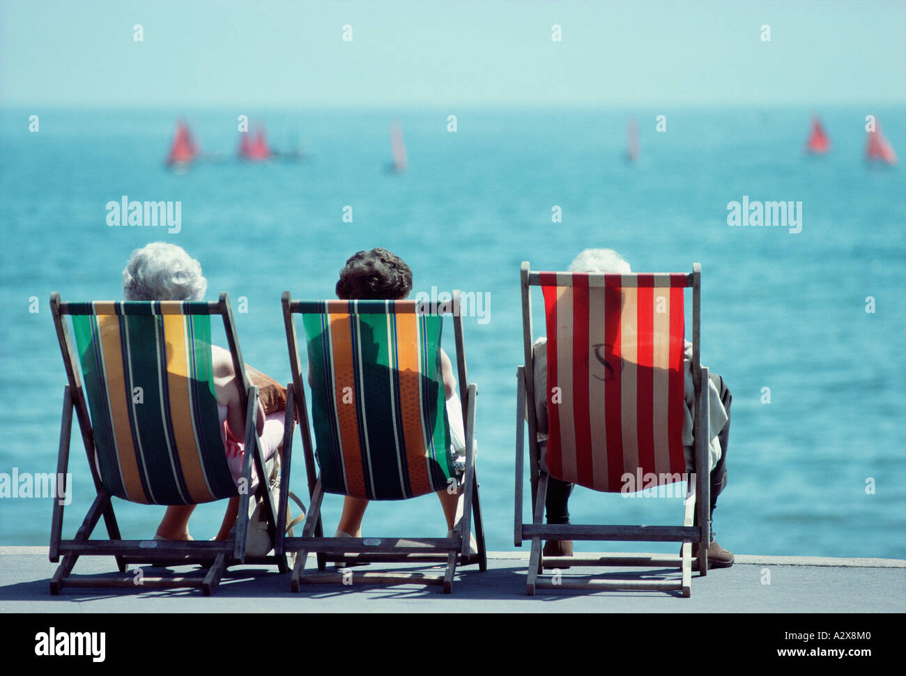 Three old ladies sitting in deckchairs on seaside promenade Stock Photo ...