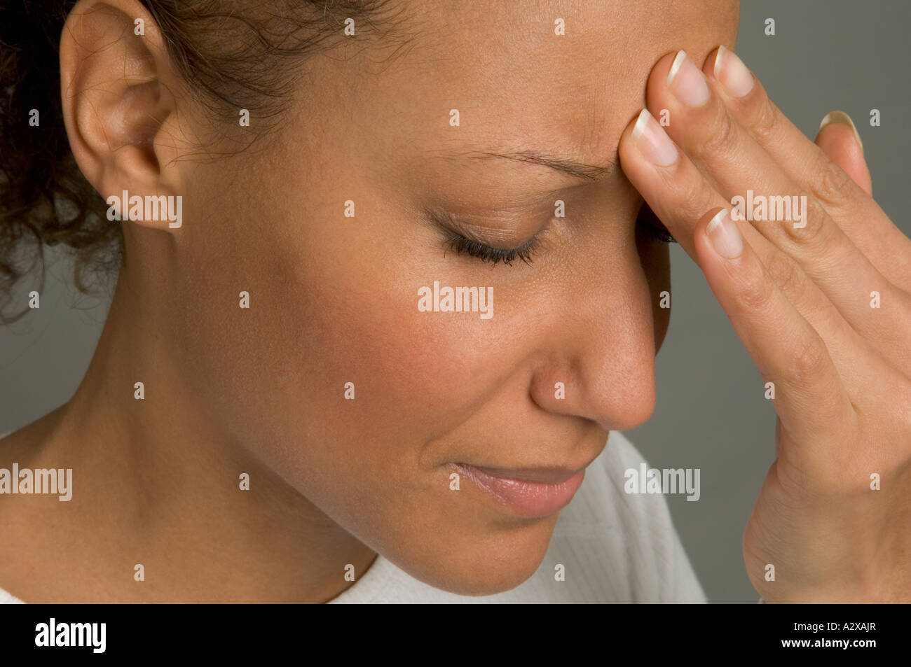 Woman with hand to her head Stock Photo - Alamy