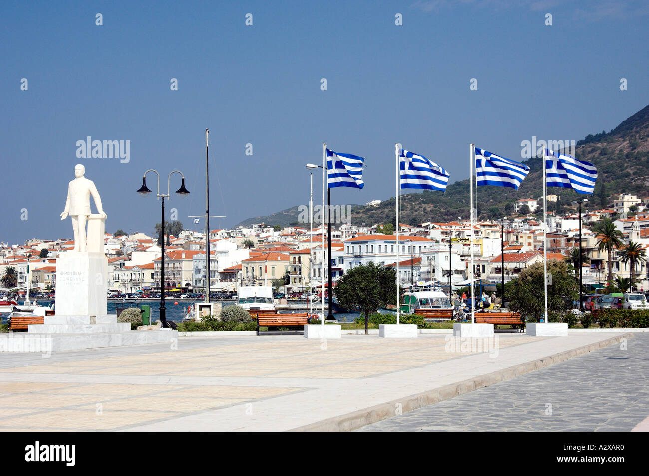 Greek flags flying at the Samos port in the village of Vathi promenade ...