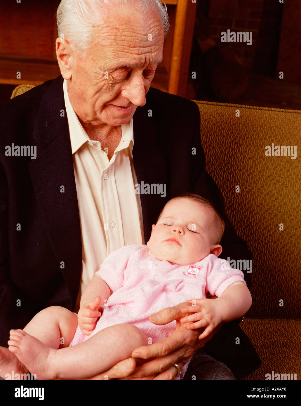 Old man holding baby indoors Stock Photo - Alamy