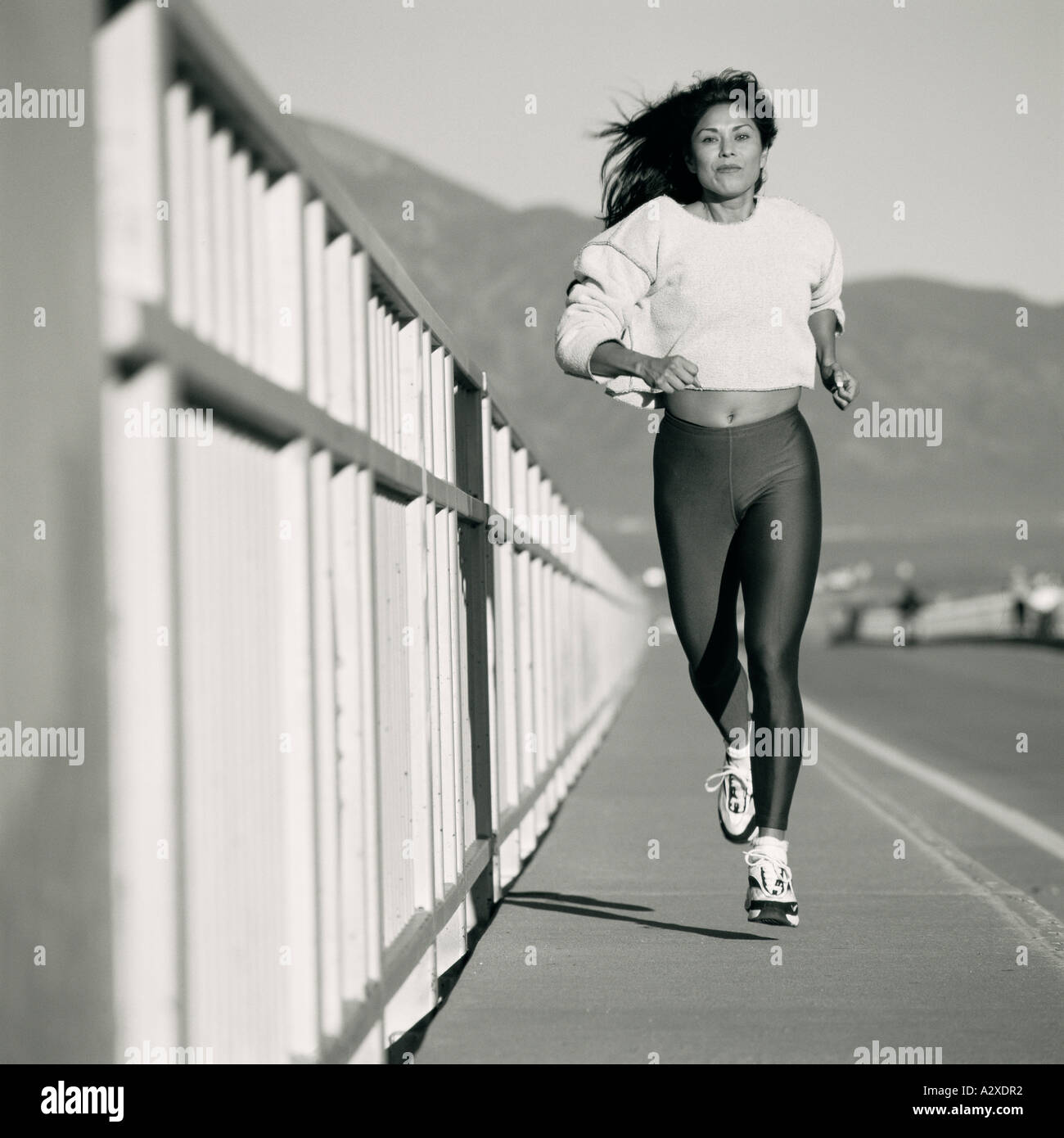 One woman running over bridge walkway outdoors Stock Photo - Alamy